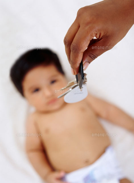 Hand holding keys in front of a baby boy[01809012225]の写真素材・イラスト素材｜アマナイメージズ