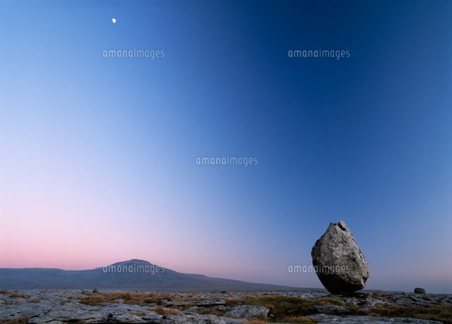 Boulder on limestone pavement at dusk[20023004710]の写真素材・イラスト素材｜アマナイメージズ