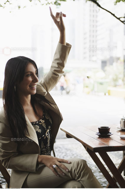 Woman Signalling Waiter at Cafe[20025182303]の写真素材・イラスト素材｜アマナイメージズ