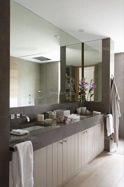 Huge mirror in modern bathroom with two sunken sinks in ston ...