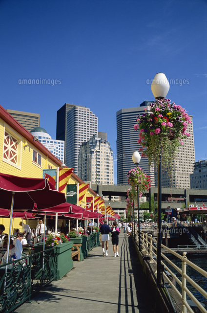 Cafes on Pier 56 on the waterfront with tower blocks of the city in the ...