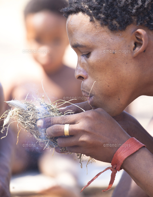 San (Bushman) demonstrating traditional fire lighting technique at the ...