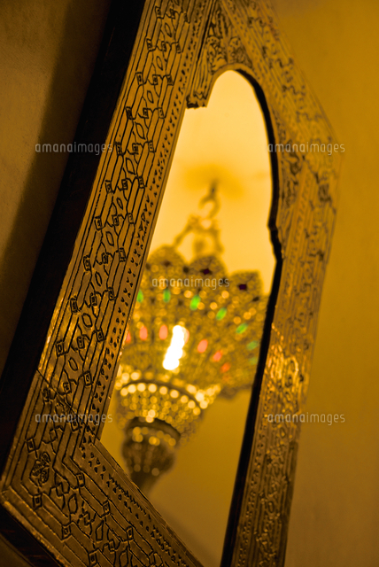 Brass ceiling lamp, reflected in typical mirror, Marrakech, Morocco ...