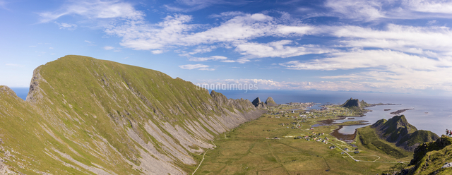 Mountain ridge frames the village of Sorland surrounded by sea, Vaeroy ...