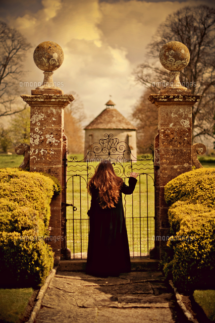 Woman at gate[20071003098]の写真素材・イラスト素材｜アマナイメージズ