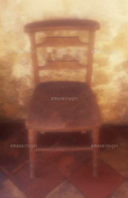 Atmospheric old upright chair in soft warm light standing on red and ...