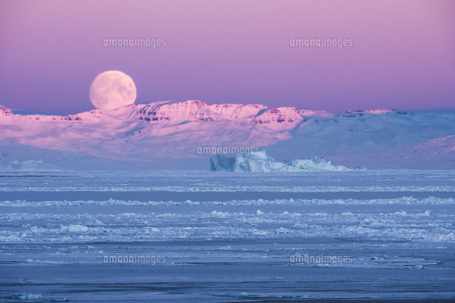 Moon set and sunrise over the Inuit settlement of Oqaatsut, West ...
