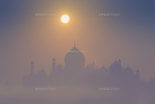 India, Taj Mahal memorial on a foggy morning with the sun rising in the ...