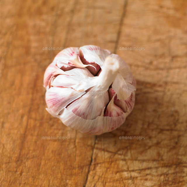 A garlic bulb on a wooden background[22199045674]の写真素材・イラスト素材｜アマナイメージズ