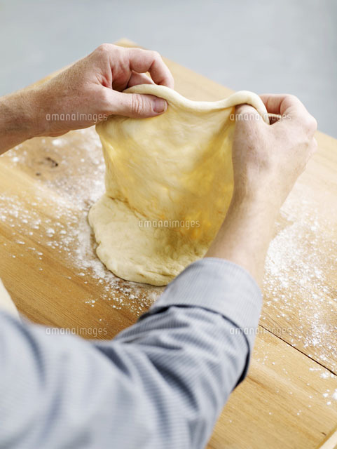 Making pizza dough (pulling the dough)[22199052951]の写真素材・イラスト素材｜アマナイメージズ
