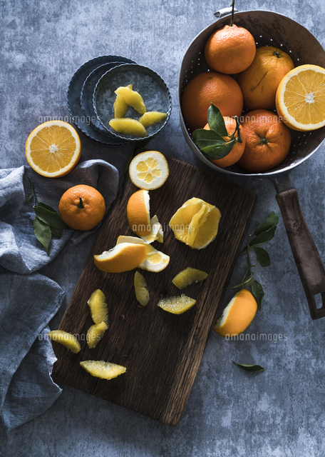 Fresh oranges in a metal colander, with orange fillets on a wooden ...