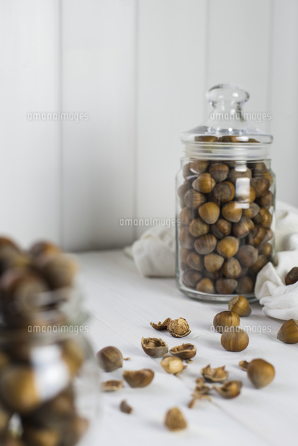 Loose hazelnuts on a table and in a glass storage jar[22199086878]の写真素材 ...
