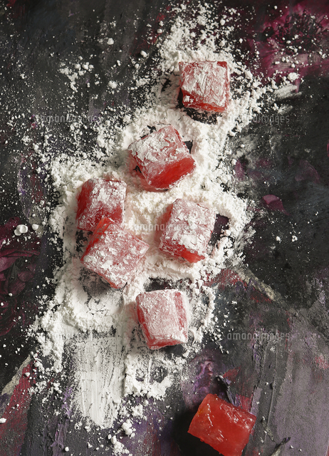 Homemade turkish delight being rolled through icing sugar coating ...