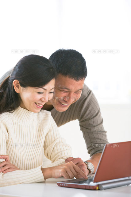 パソコンをする夫婦[02022347337]の写真素材・イラスト素材｜アマナイメージズ