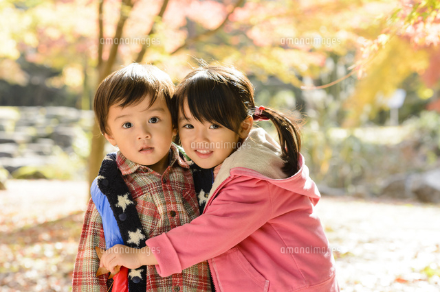 紅葉の公園で男の子に抱きつく女の子 10264009205 の写真素材・イラスト素材｜アマナイメージズ 