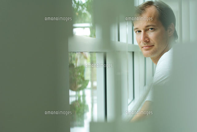 Man by window, selective focus[11001035606]の写真素材・イラスト素材｜アマナイメージズ