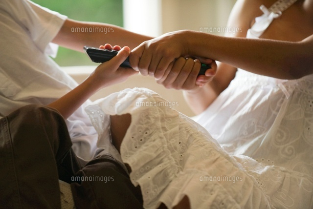 Children fighting over remote control, cropped[11001052089]の写真素材・イラスト素材 ...
