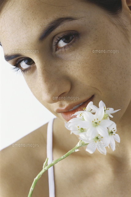 Young woman holding white flowers, portrait[11001061307]の写真素材・イラスト素材 ...