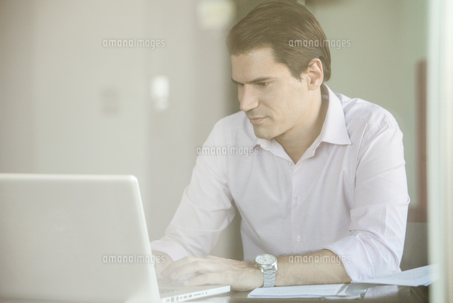 Man using laptop computer in office[11001062168]の写真素材・イラスト素材｜アマナイメージズ