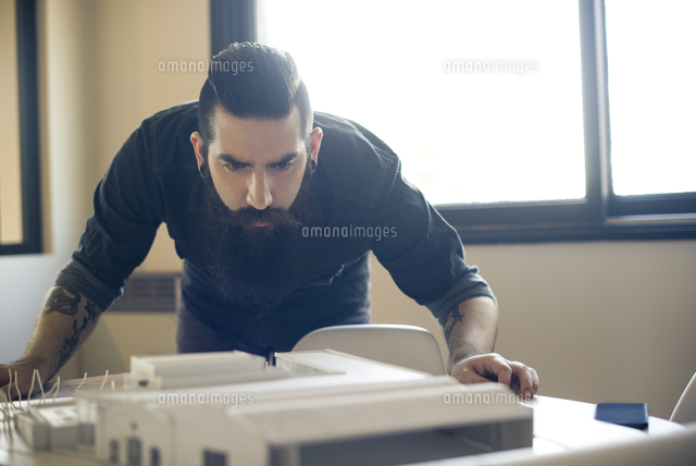 Architect looking at model building[11001067033]の写真素材・イラスト素材｜アマナイメージズ