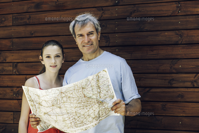 Father and daughter standing with map[11001069571]の写真素材・イラスト素材｜アマナイメージズ
