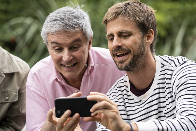Father and son looking at smartphone[11001072707]の写真素材・イラスト素材｜アマナイメージズ