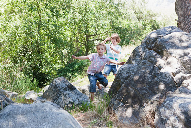 Boys walking through rocks[11015196340]の写真素材・イラスト素材｜アマナイメージズ