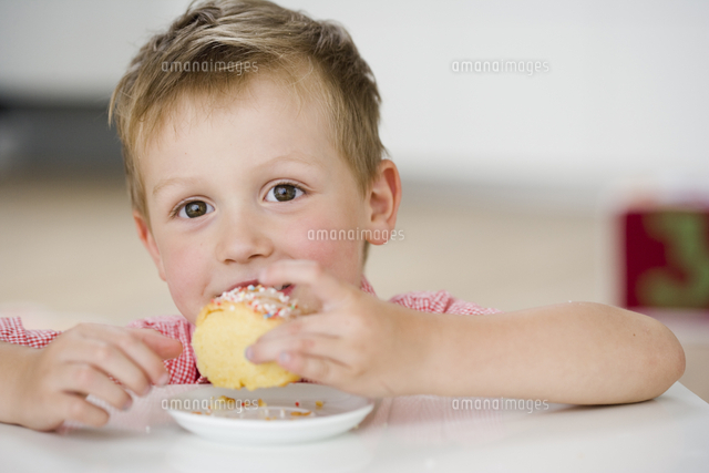 Young boy eating sweet dumpling[11015216196]の写真素材・イラスト素材｜アマナイメージズ