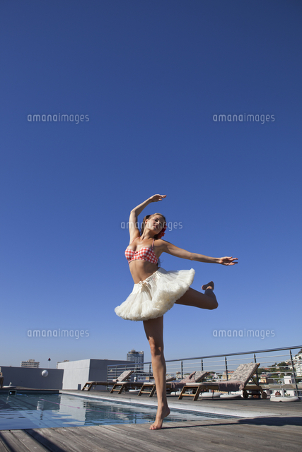 Woman in tutu dancing by pool[11015222974]の写真素材・イラスト素材｜アマナイメージズ