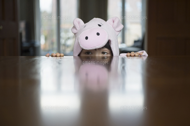 Boy in costume peering over table[11015244176]の写真素材・イラスト素材｜アマナイメージズ