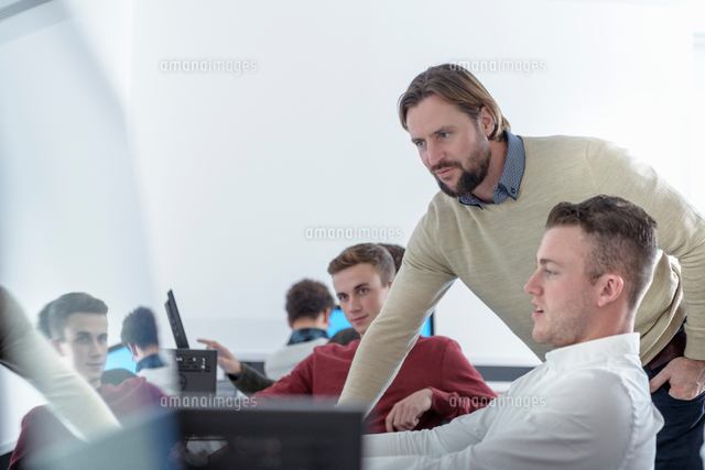 Teacher with engineering apprentices in classroom of railway ...