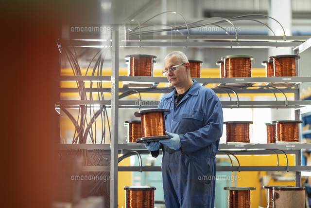 Electrical engineer with reel of copper wire in electrical engineering ...