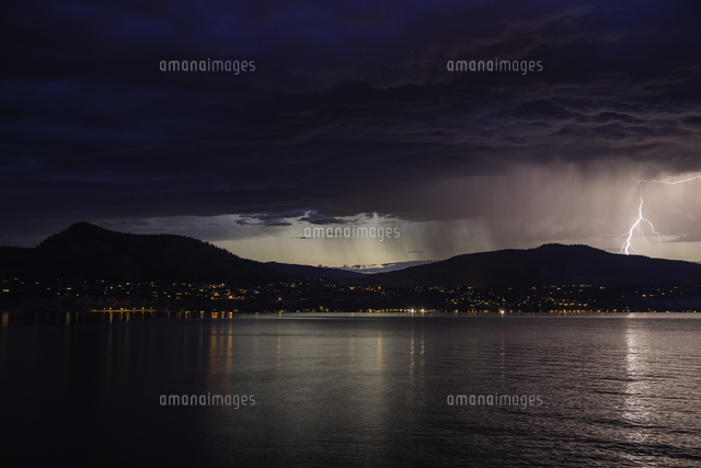 Lightning bolts during a thunderstorm over mountains, Canada ...