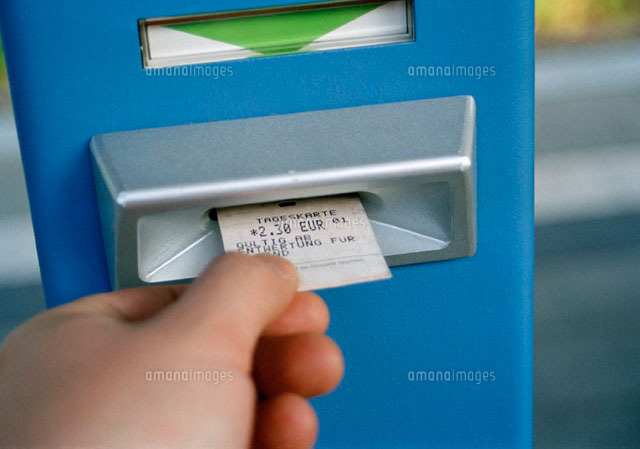 A hand inserting a ticket[11016014548]の写真素材・イラスト素材｜アマナイメージズ
