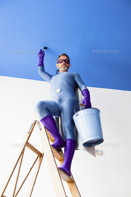 Low angle portrait of superhero painting ceiling while standing on ...