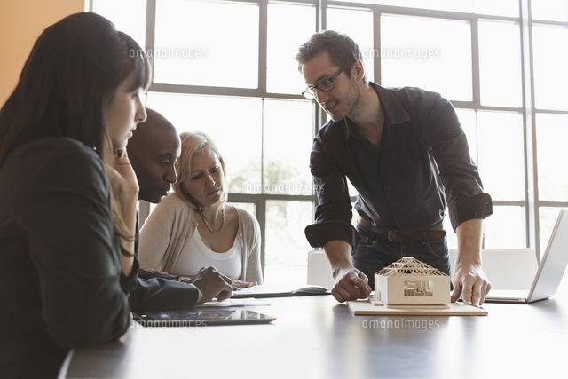 Business people examining model in meeting[11018045141]の写真素材・イラスト素材｜アマナ ...