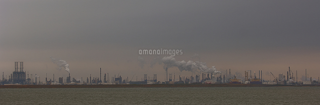 Smoke billowing from distant factory[11018051129]の写真素材・イラスト素材｜アマナイメージズ