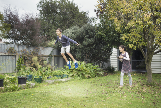 Mixed race children playing with hover toy in backyard[11018057400]の写真 ...