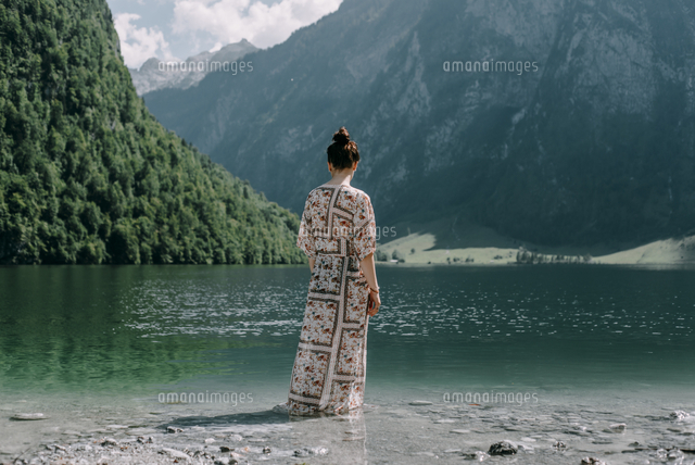 Caucasian woman wading in mountain lake[11018091184]の写真素材・イラスト素材｜アマナイメージズ