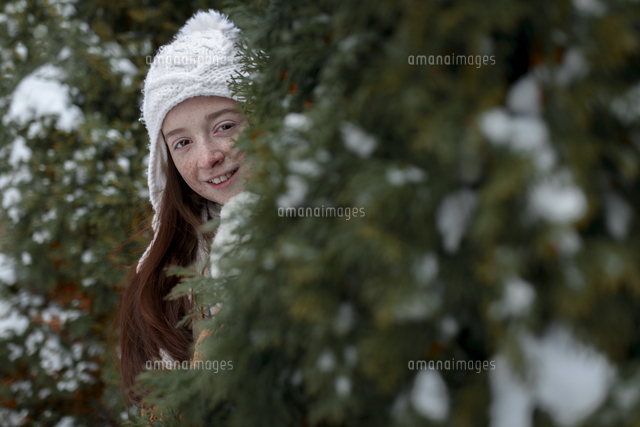 Portrait of Caucasian girl hiding behind tree in winter[11018095721]の写真 ...