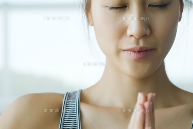 Young woman meditating in prayer position[11025007164]の写真素材・イラスト素材｜アマナイメージズ