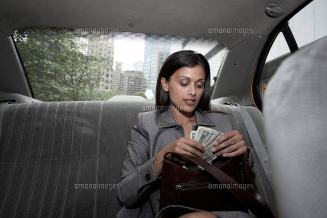Woman counting money in backseat of taxi[11029003024]の写真素材・イラスト素材｜アマナイメージズ
