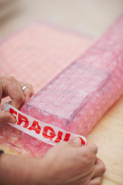 Man’s Hands Wrapping Fragile Goods[11030022462]の写真素材・イラスト素材｜アマナイメージズ