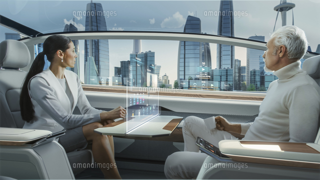 Man and woman in a driverless car[11068009633]の写真素材・イラスト素材｜アマナイメージズ