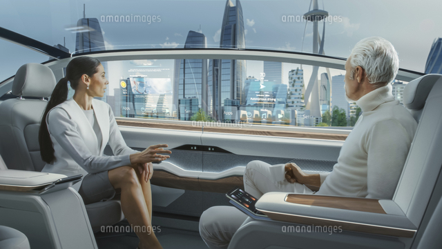 Man and woman in a driverless car[11068009641]の写真素材・イラスト素材｜アマナイメージズ