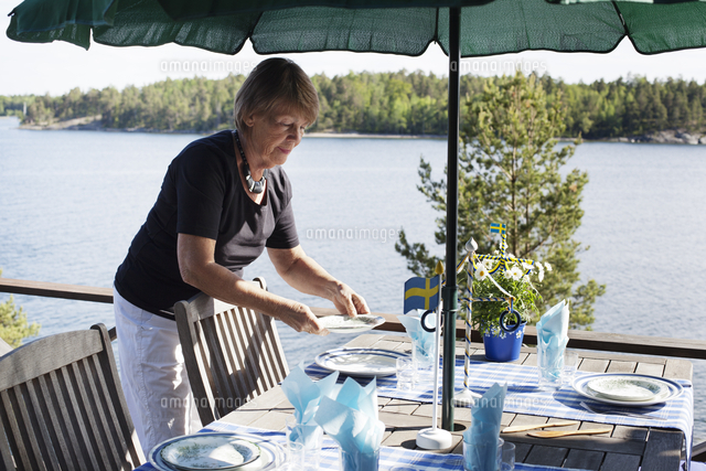 Mature woman setting table[11077006819]の写真素材・イラスト素材｜アマナイメージズ