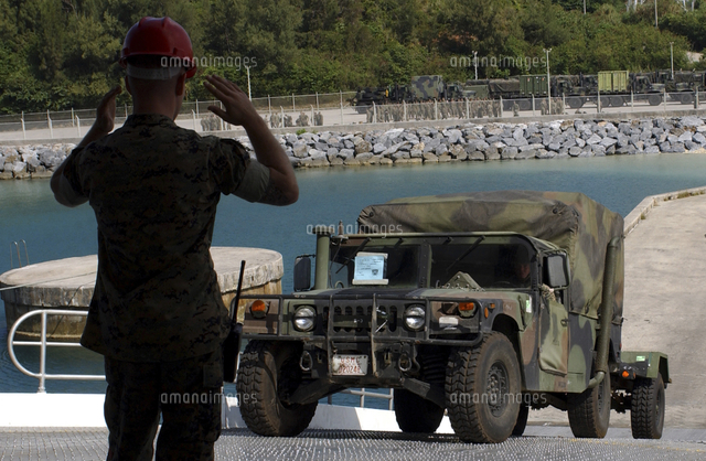 A specialist directs a humvee aboard the high-speed vessel W ...