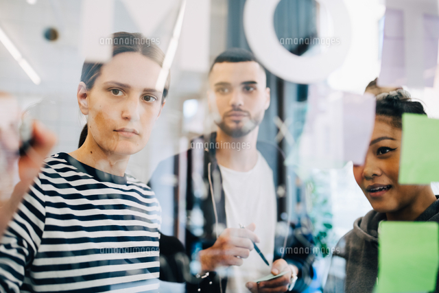 Young multi-ethnic hackers discussing strategy over glass during ...