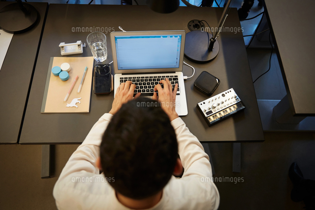 High angle view of businessman using laptop at desk in creative office ...