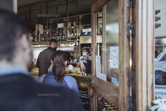 Customers maintaining social distancing while collecting order from ...